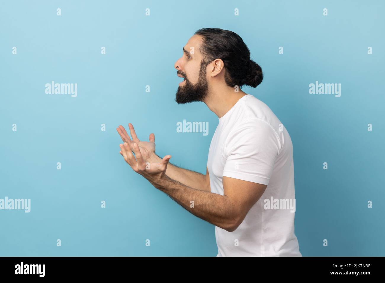 What do you want. Side view of angry confused man standing with raised ...
