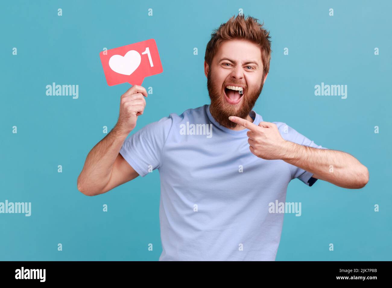 Portrait of excited positive bearded man pointing at red like counter ...