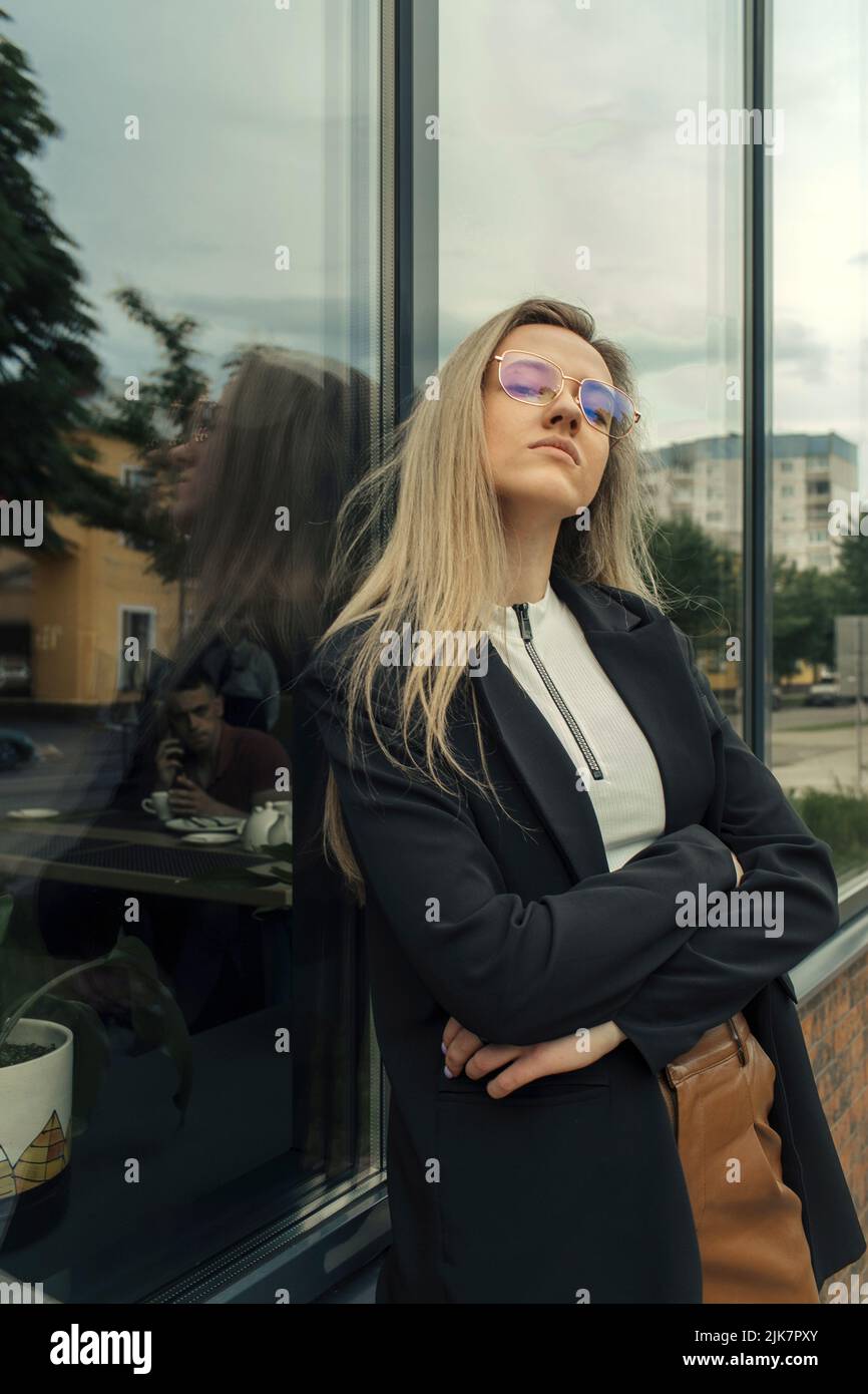 Woman leaning against glass window hi-res stock photography and images ...