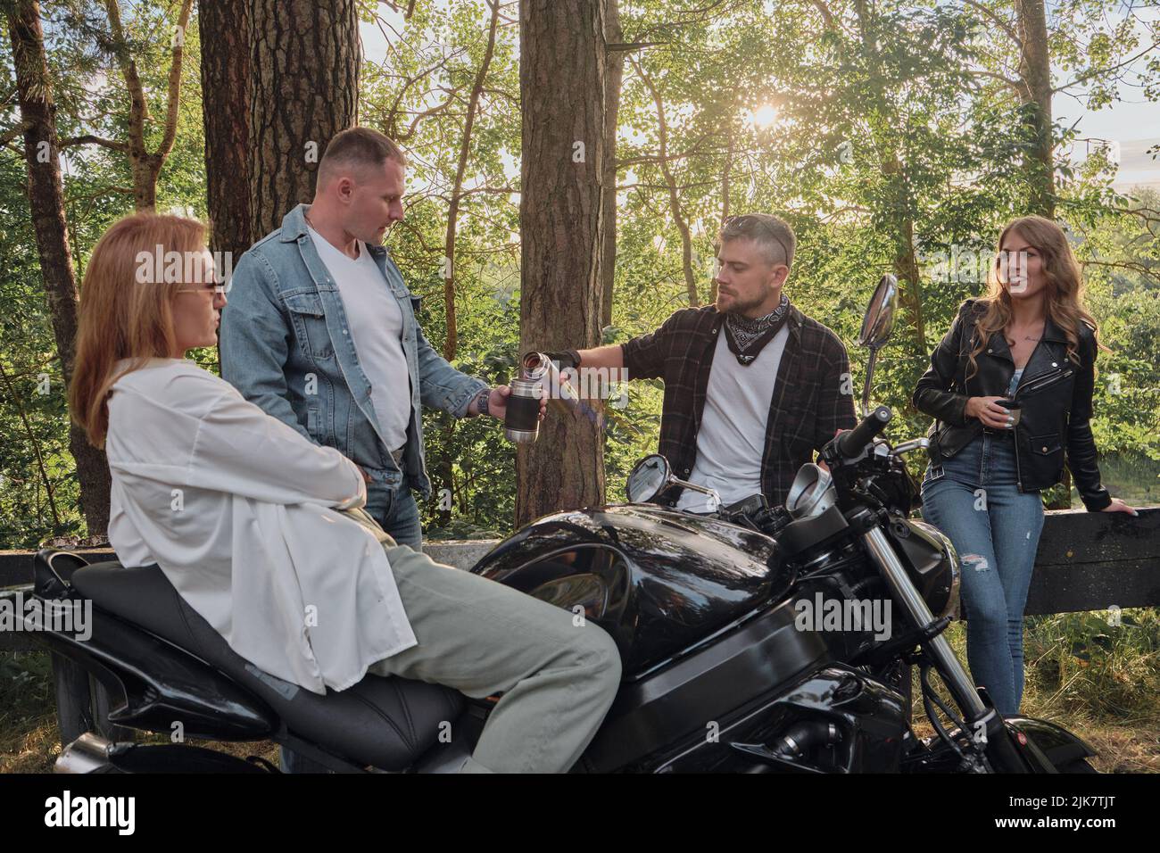 A company of friends travel together on motorcycles, stopped at the ...