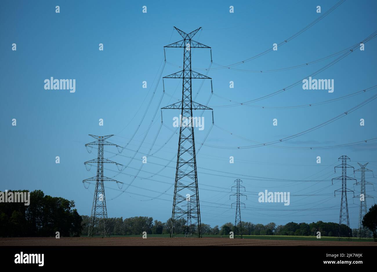 High voltage grid. Tall metal structures with electric cables standing ...