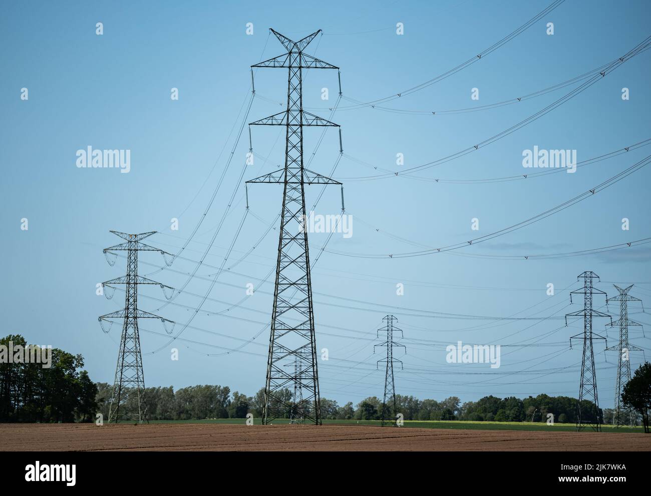 High voltage grid. Tall metal structures with electric cables standing ...