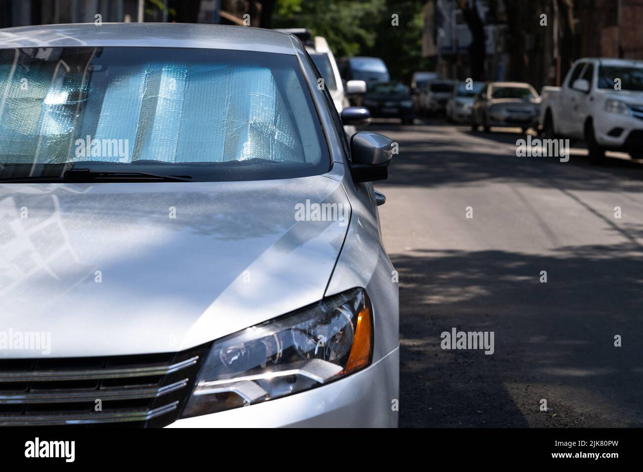 Protective reflective surface under windshield of car on hot day ...