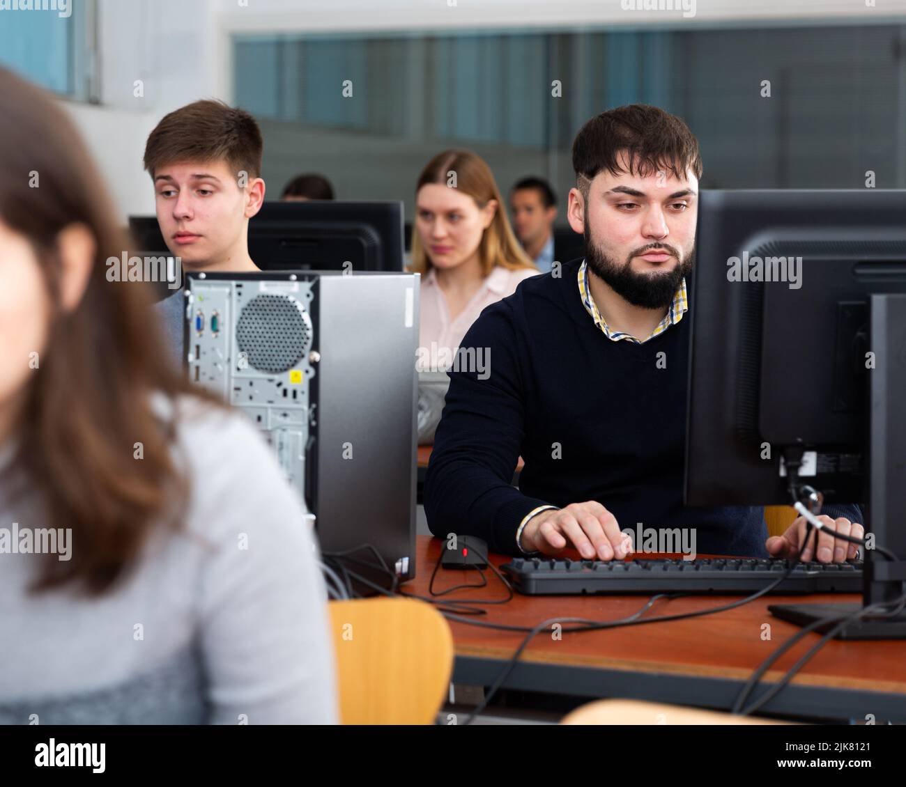 Group of people of different ages learning to use computers in ...