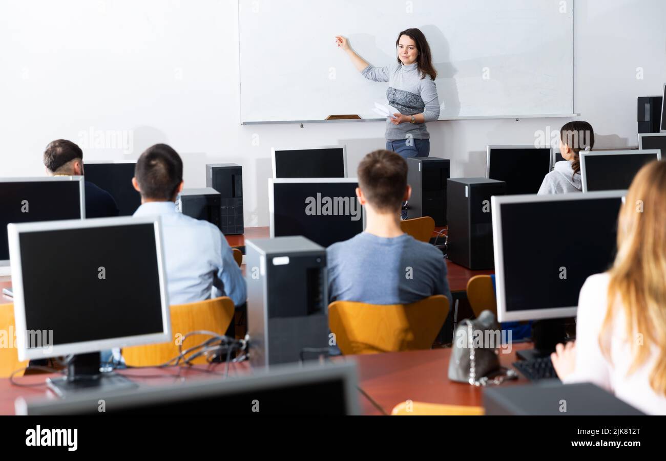 Woman lecturing students in computer room Stock Photo - Alamy