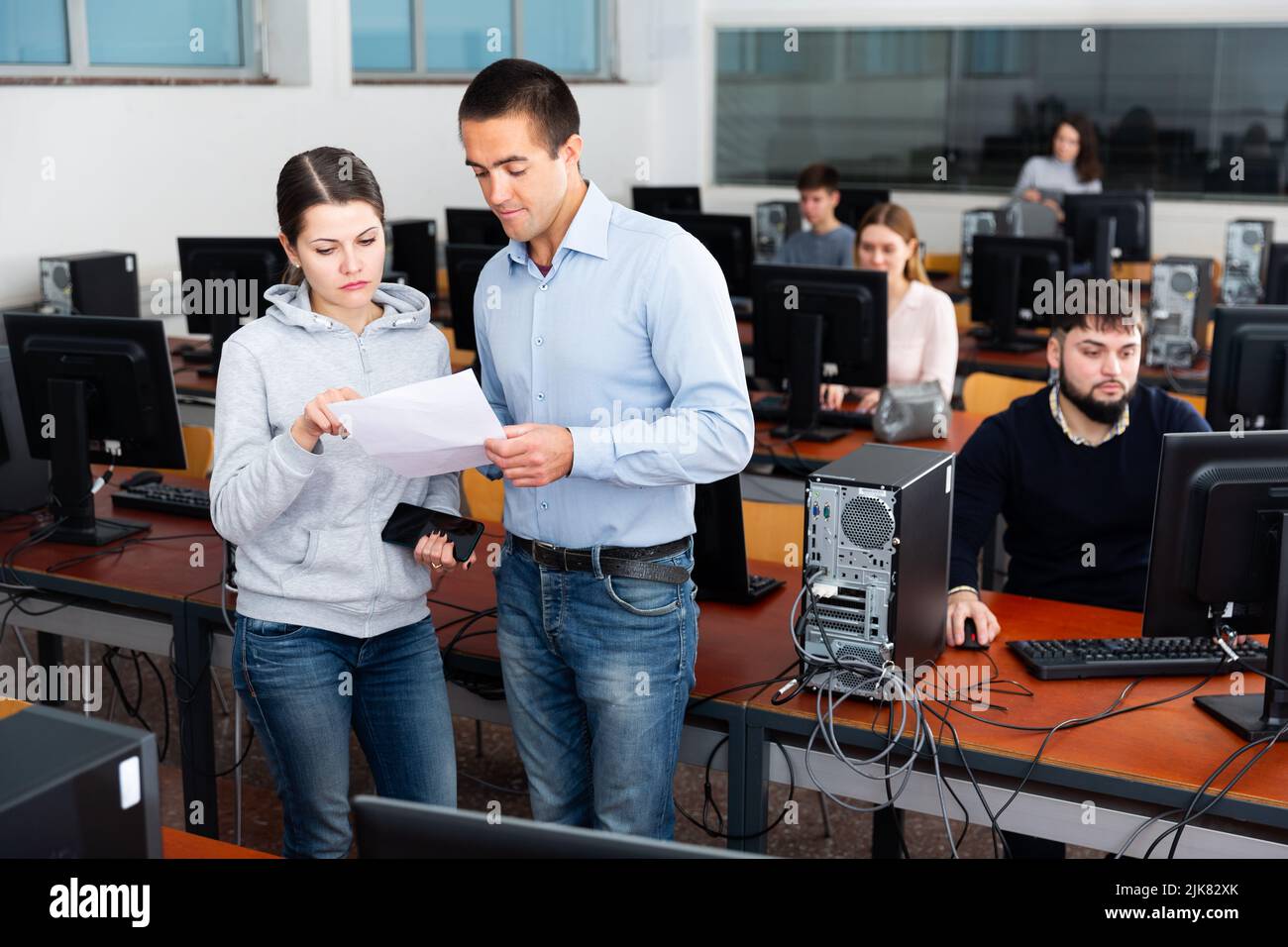 Man and woman communicating at computer class Stock Photo - Alamy