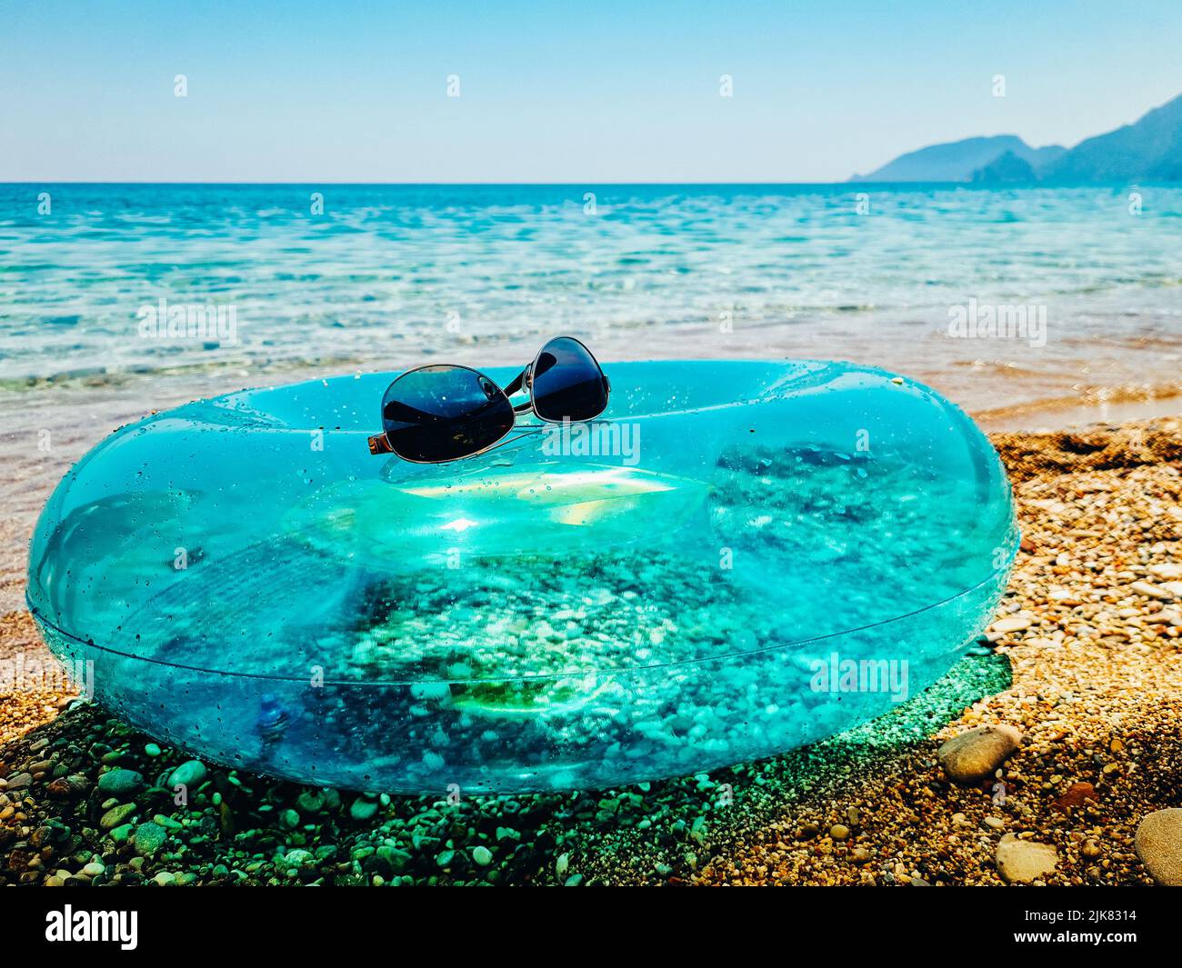 Blue inflatable swim ring float and sunglasses on the beach Stock Photo ...