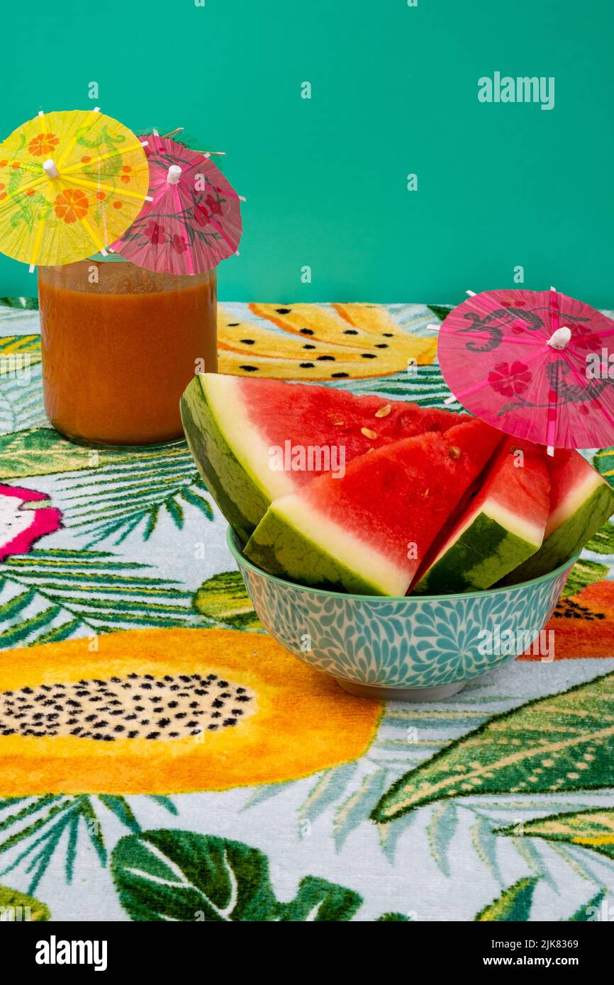 Freshly cut watermelon with a small umbrella, a glass of gazpacho on a ...