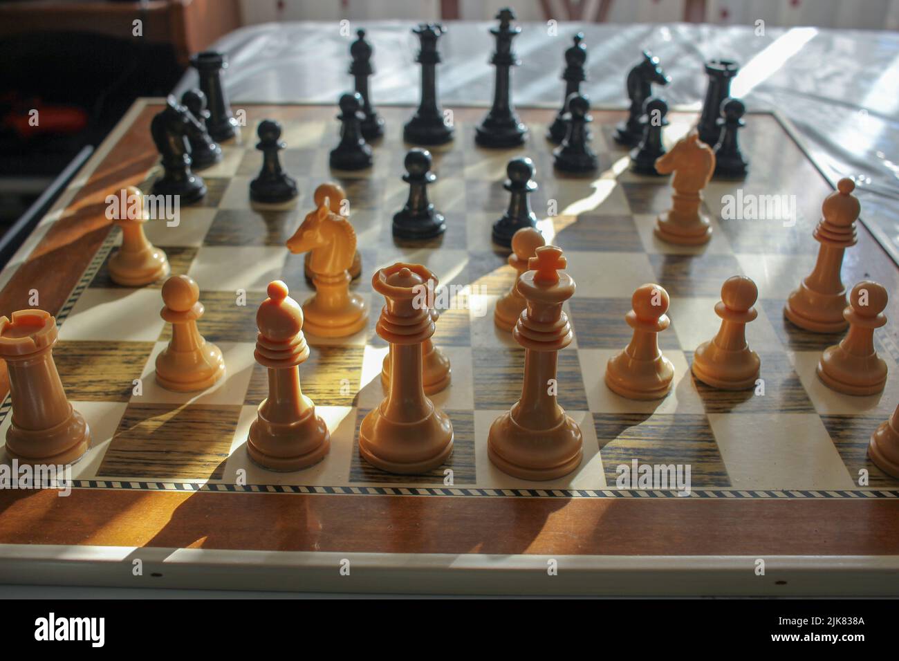 lights and shadows of a game of chess in my living room during sunset ...