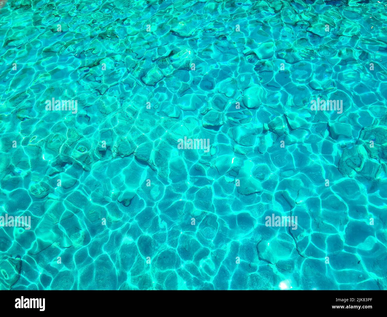 Turquoise surface of transparent sea water with sun glints Stock Photo ...