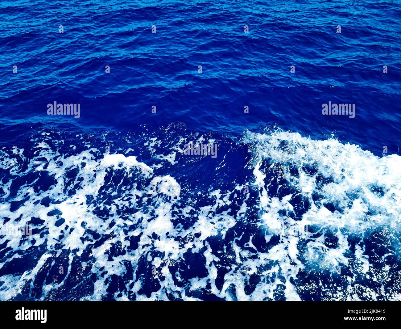 Deep blue surface of transparent sea water with sun glints Stock Photo ...