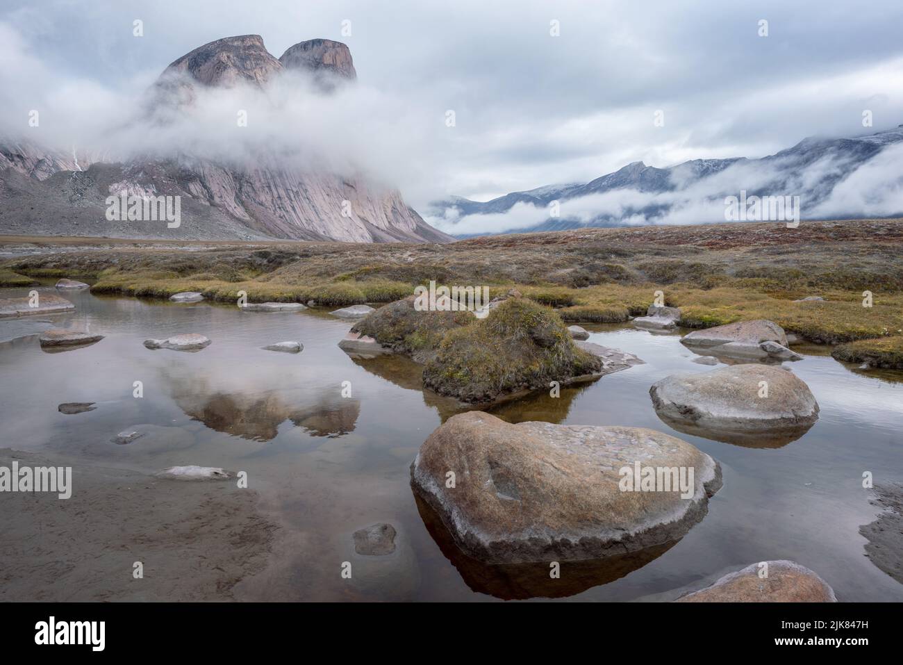 Majestic granite rocks reflect in water surface. Wild arctic landscape ...