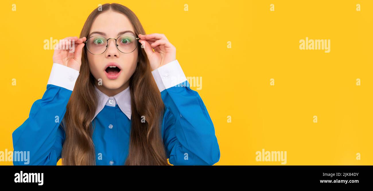 Shocked school aged girl child in spectacles with amazed look yellow ...