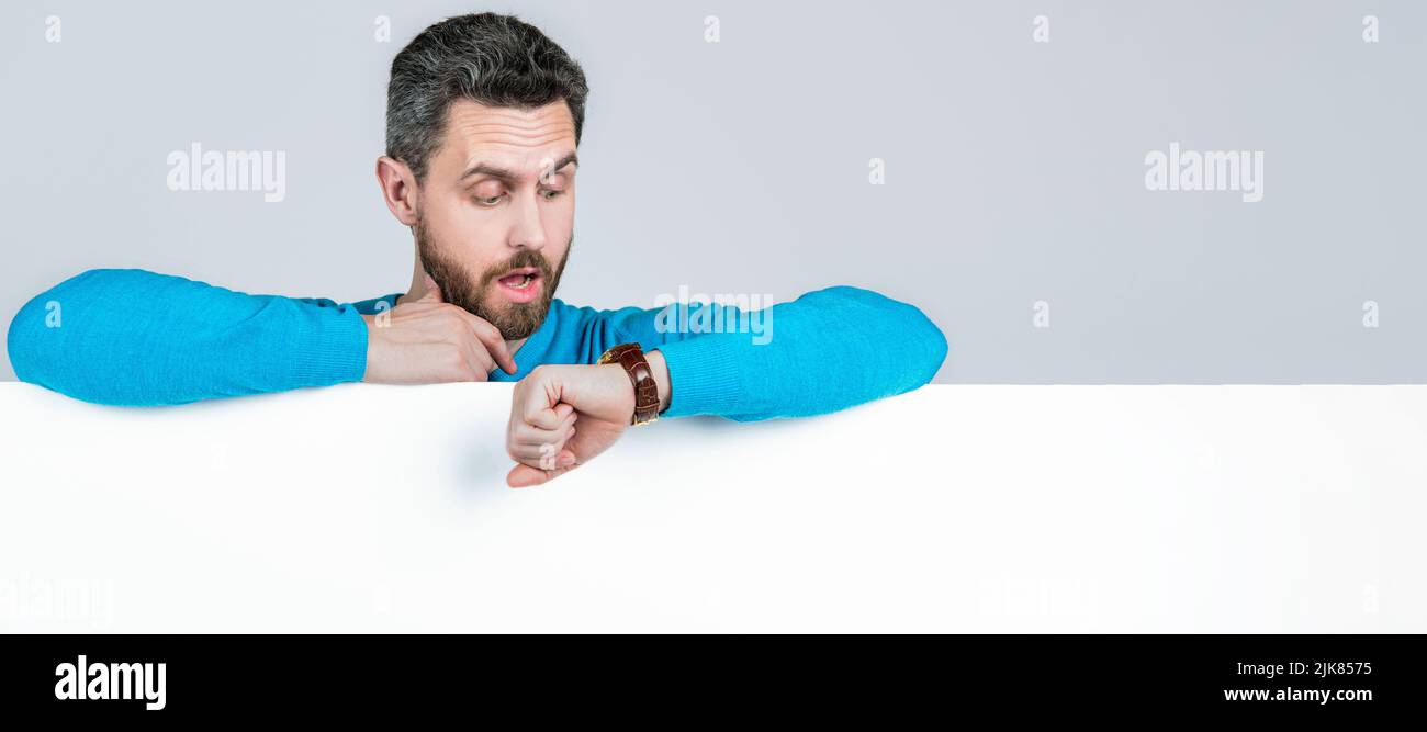 Man face portrait, banner with copy space. shocked man checking time ...