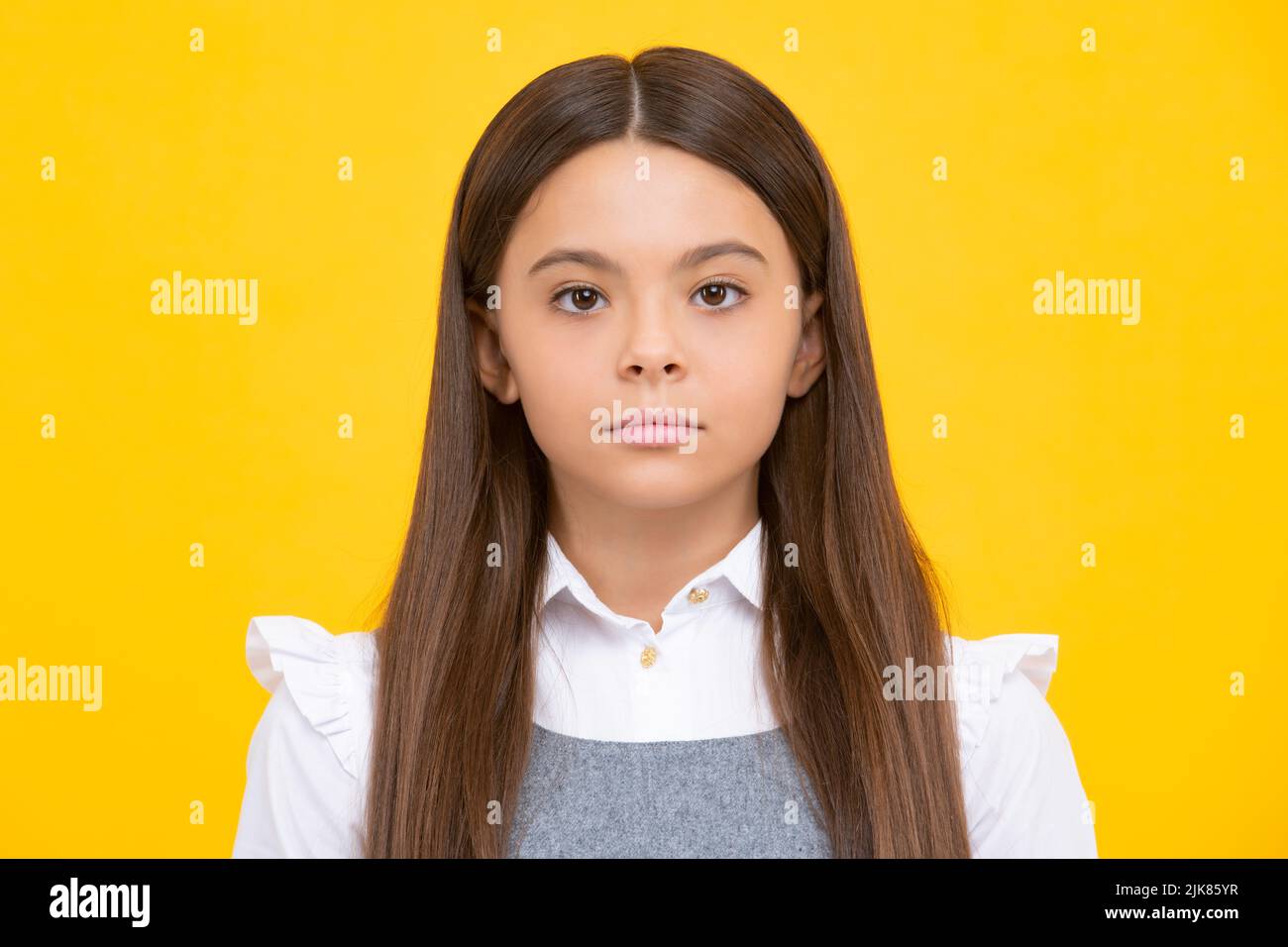 Portrait of cute smart clever little girl isolated on yellow background ...
