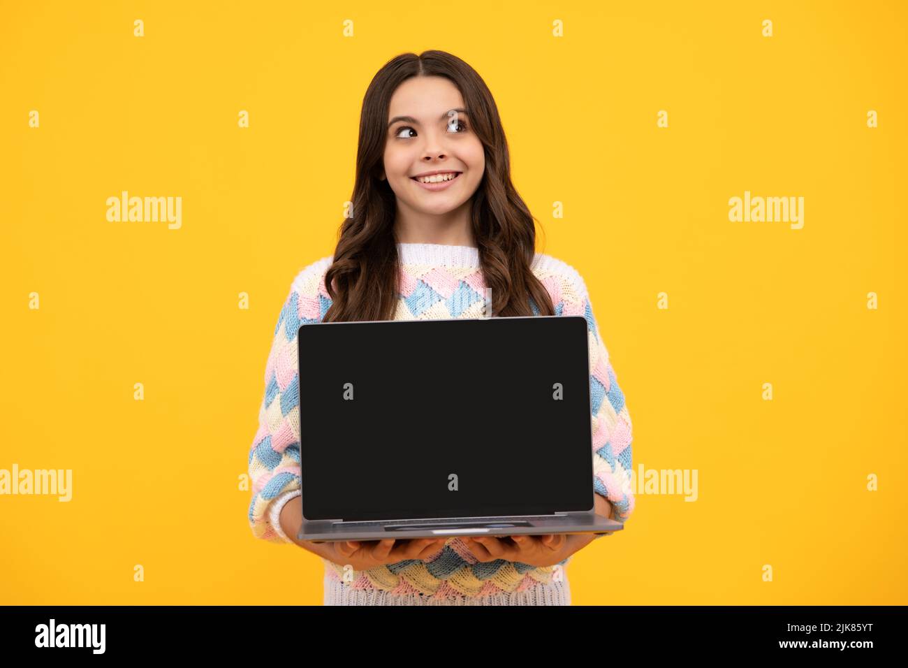 Smart girl with laptop in casual clothes isolated over yellow ...