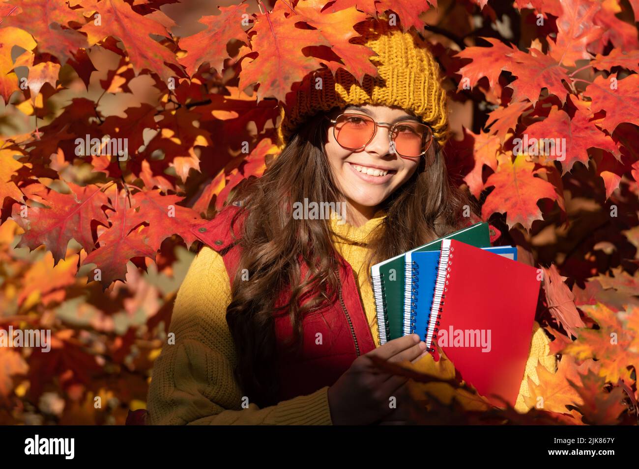 Autumn teenager girl portrait in fall autumn leaves. happy kid hold ...