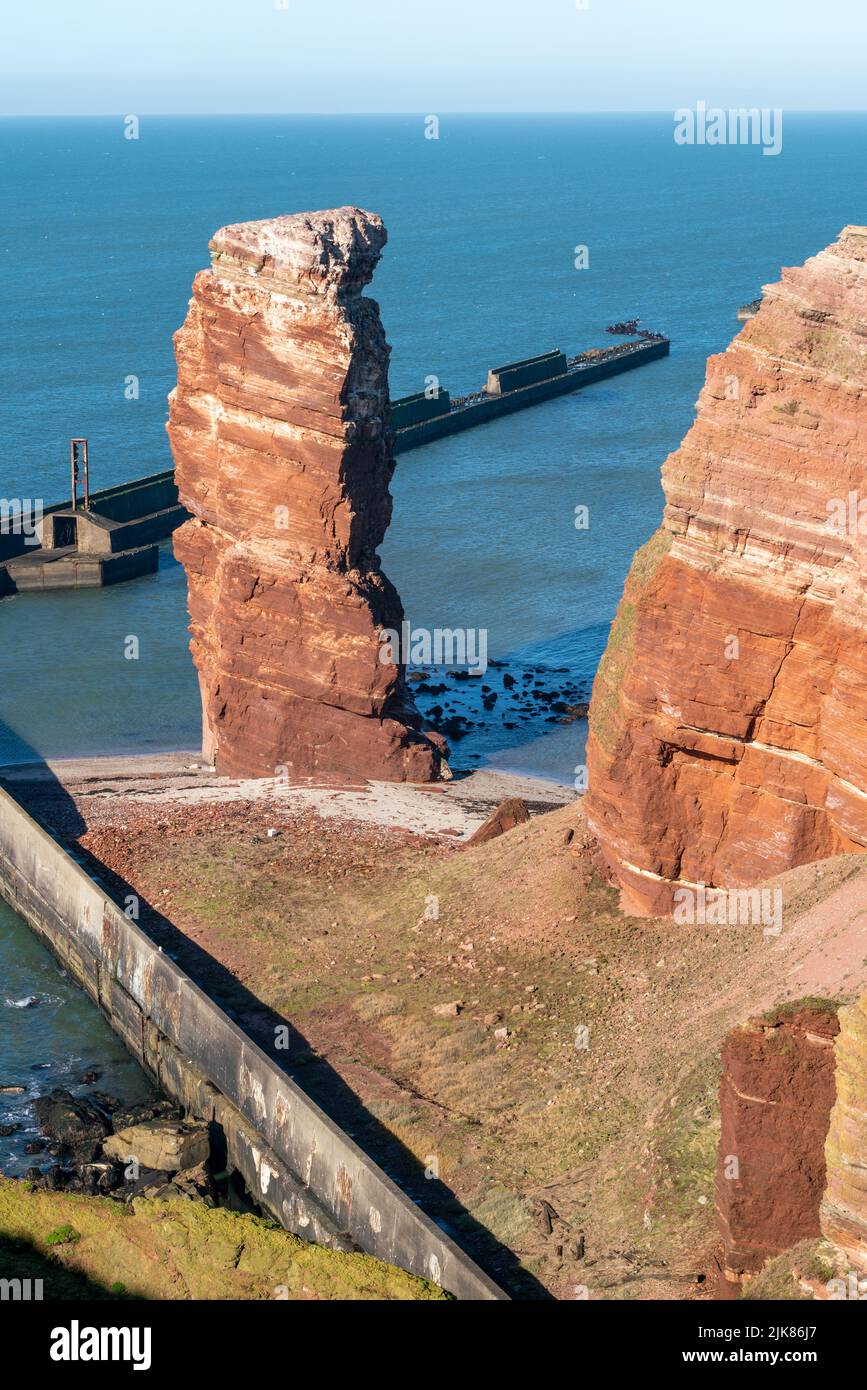 Lange Anna sea stack and tall red dramatic cliffs of Heligoland island ...
