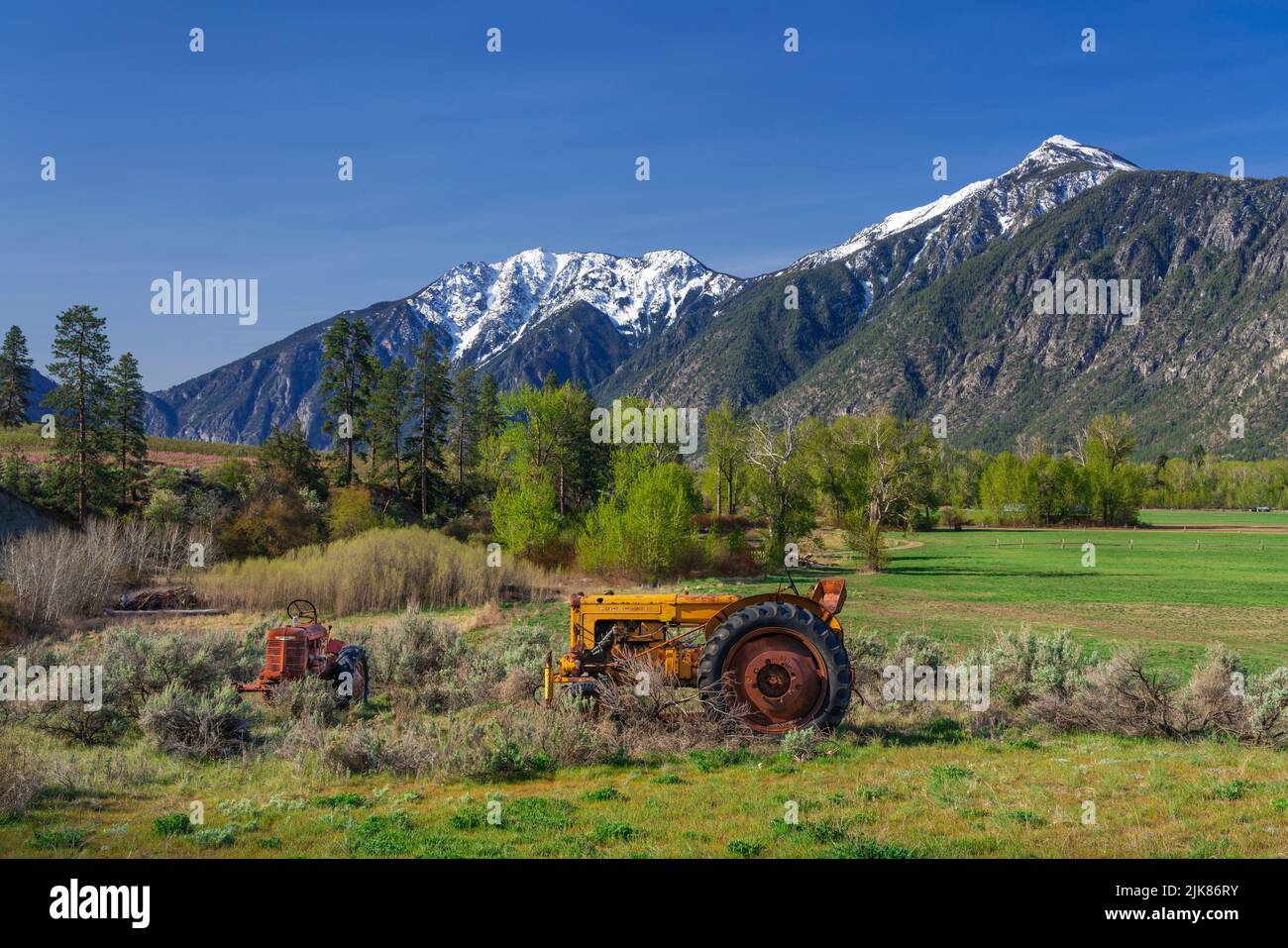 Old farm tractors in a pasture below Mount Chopaka, British Columbia ...