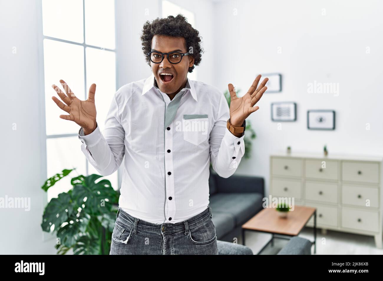 African psychologist man at consultation office celebrating crazy and ...
