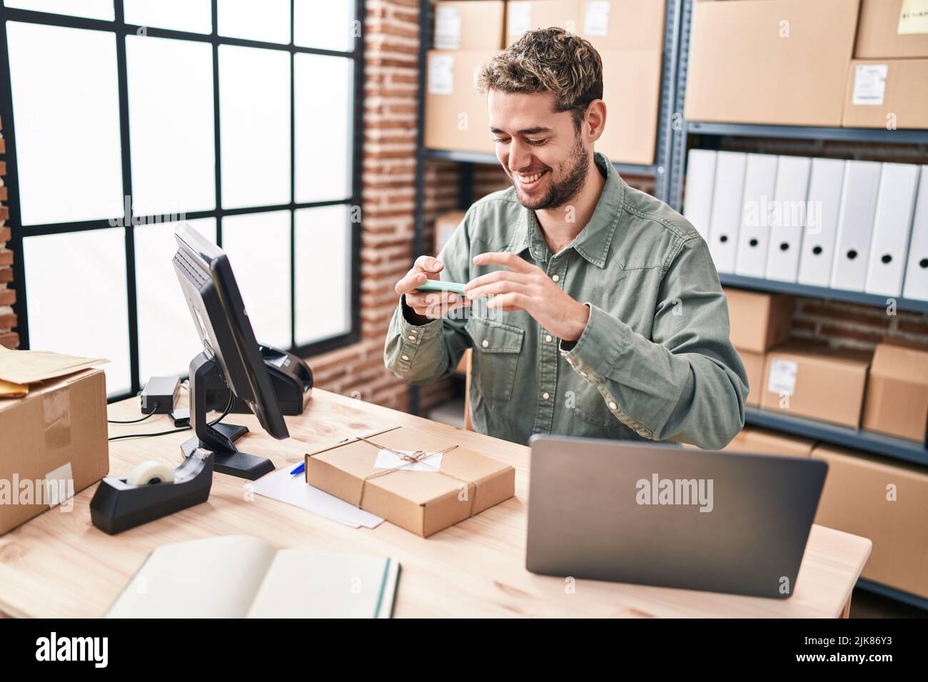 Young man ecommerce business worker make photo to package at office ...