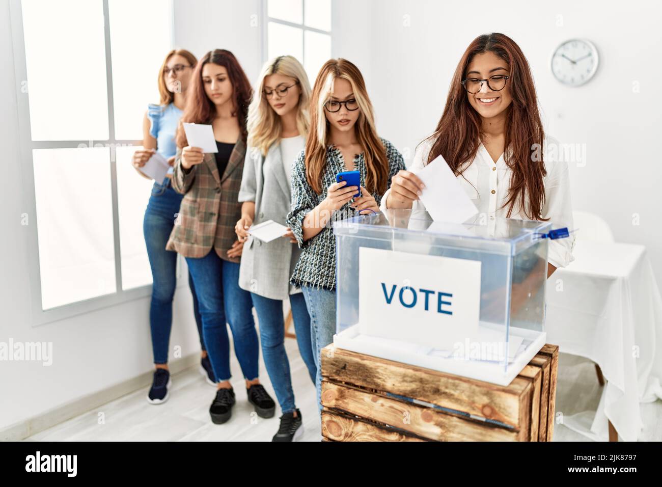 Group of young voter woman smiling happy putting vote in voting box at ...