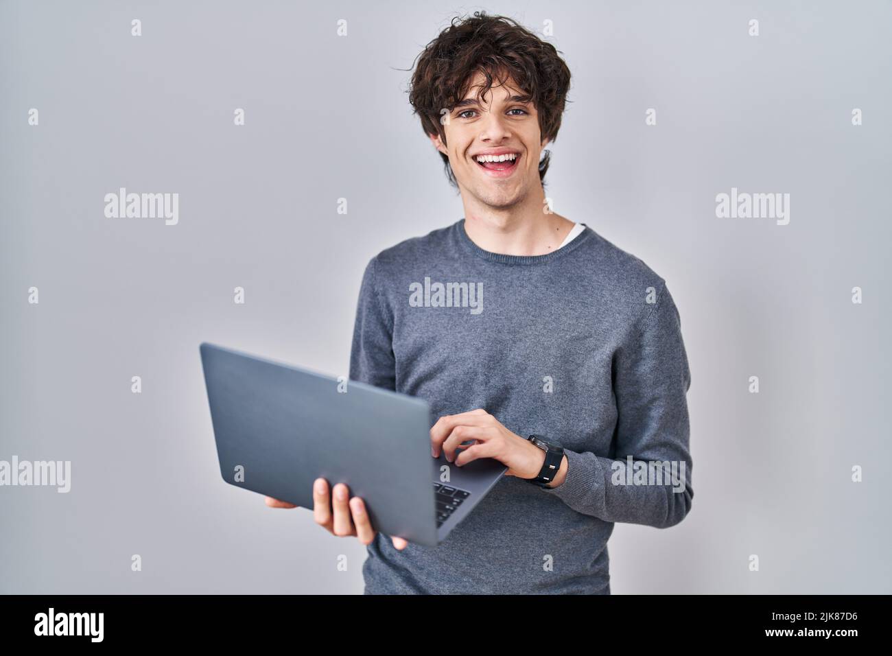 Young man working using computer laptop looking positive and happy ...