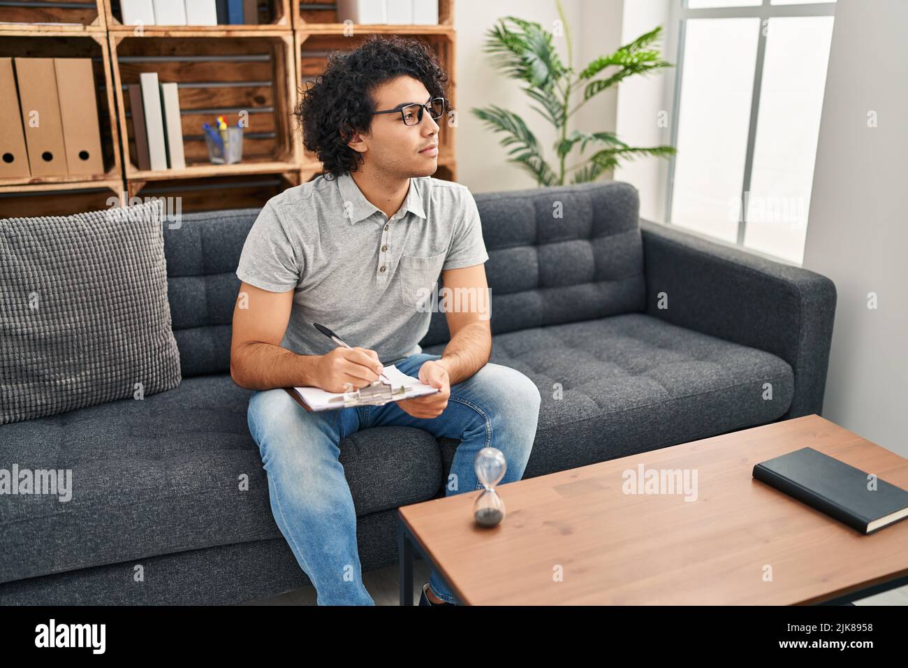 Young hispanic man psychologist having session at psychology center ...