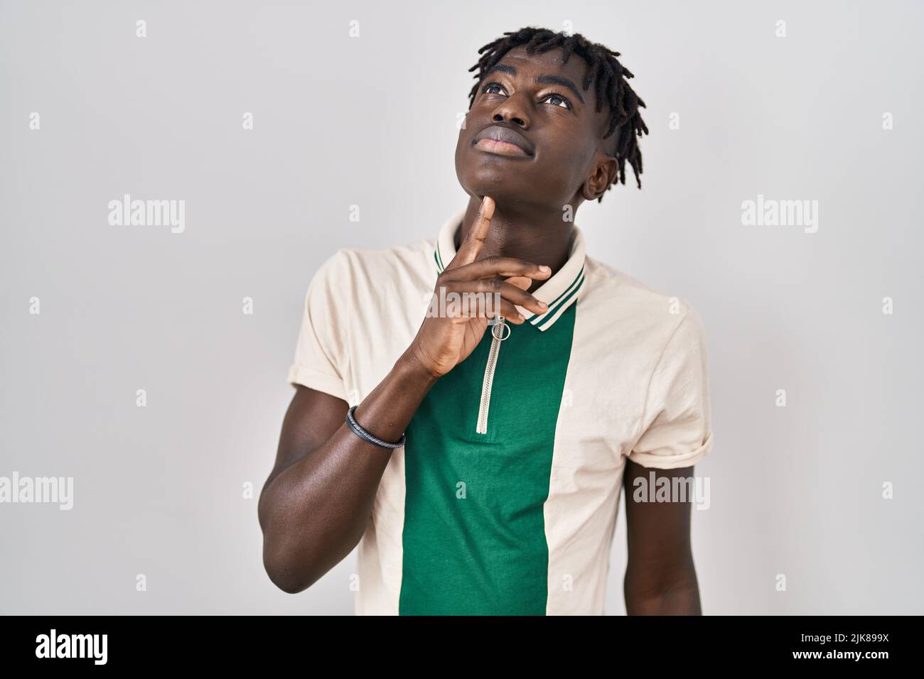 African man with dreadlocks standing over isolated background thinking ...