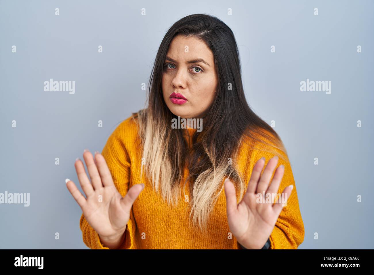 Young hispanic woman standing over isolated background moving away ...