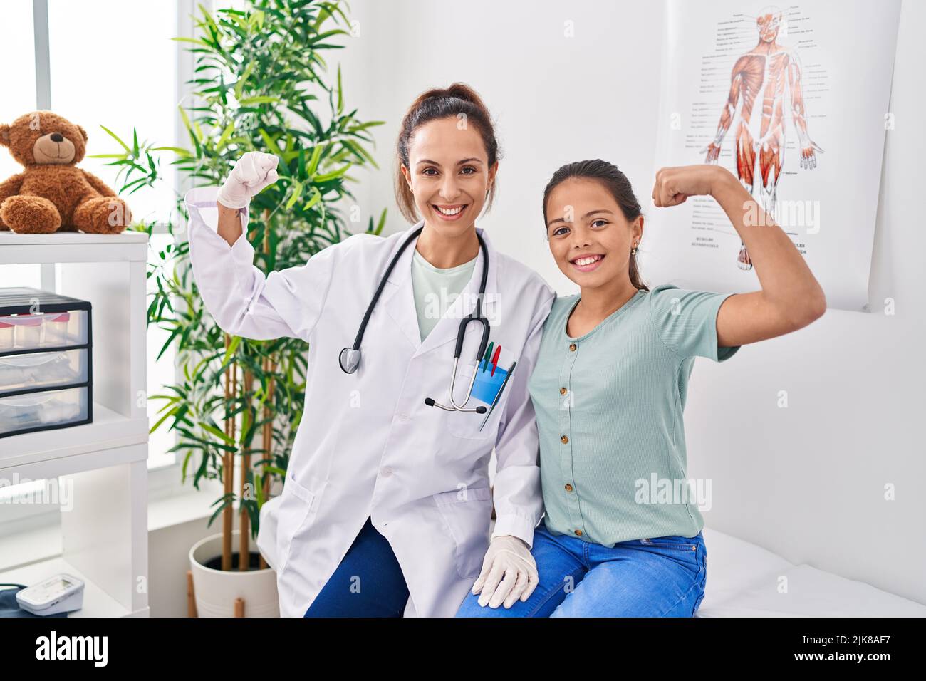 Woman and girl doctor and patient doing power gesture at clinic Stock ...