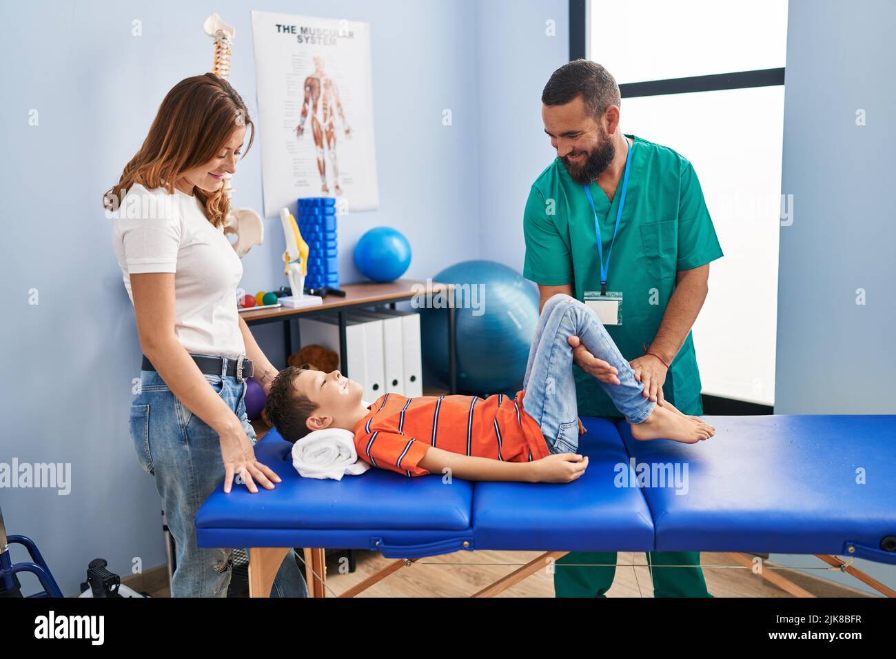Family having physiotherapy session stretching child legs at rehab ...