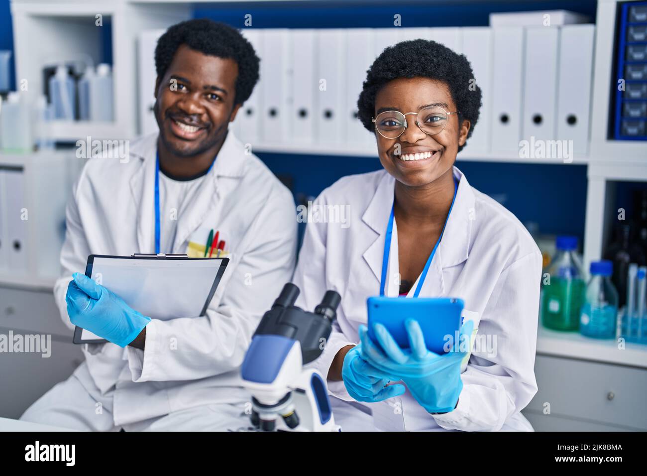 African american man and woman scientists using touchpad write on document at laboratory Stock ...