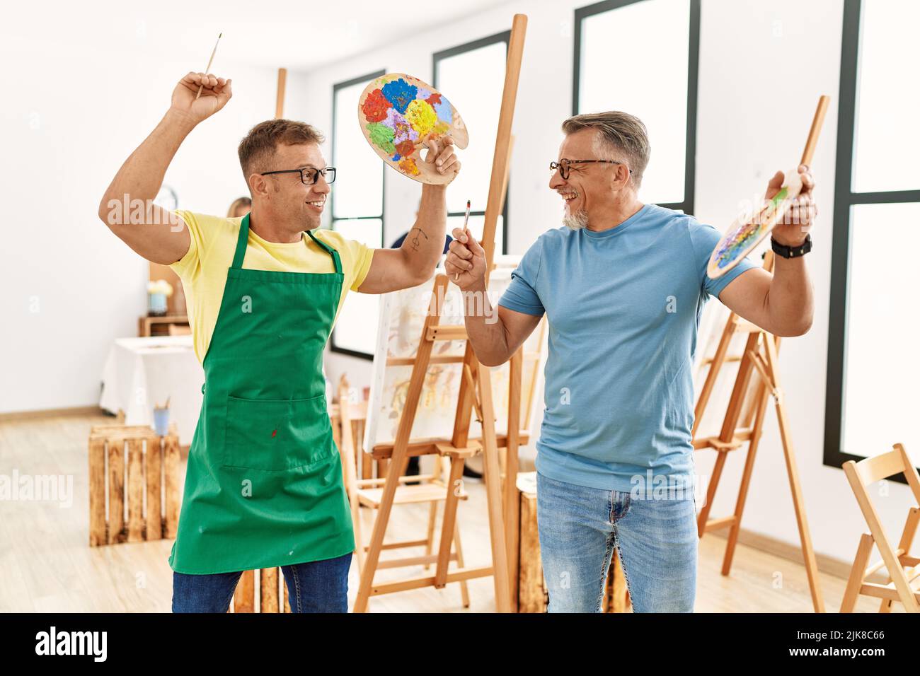 Group of middle age people drawing at art studio. Two students smiling ...