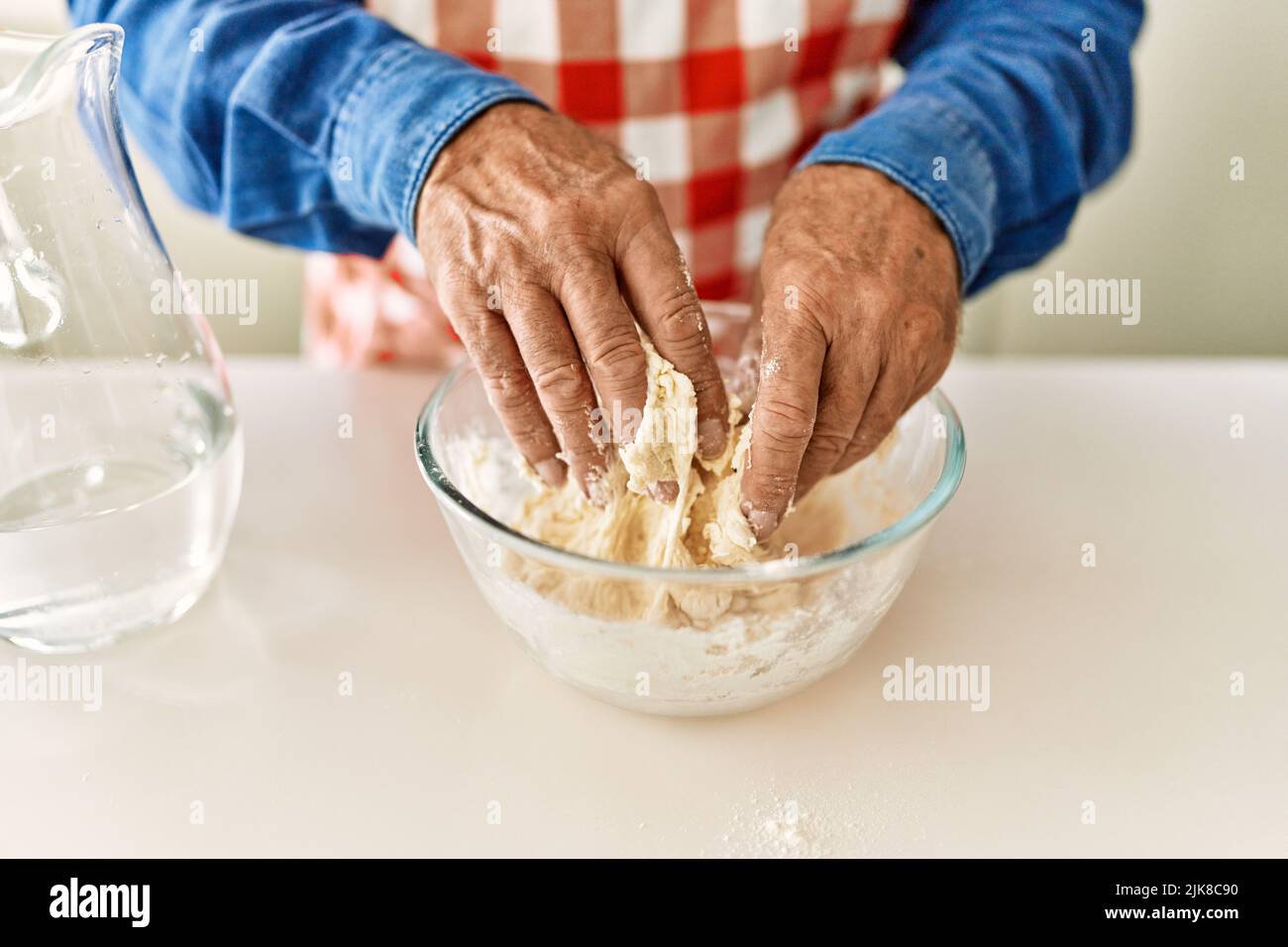 Senior man cooking dough at kitchen Stock Photo - Alamy