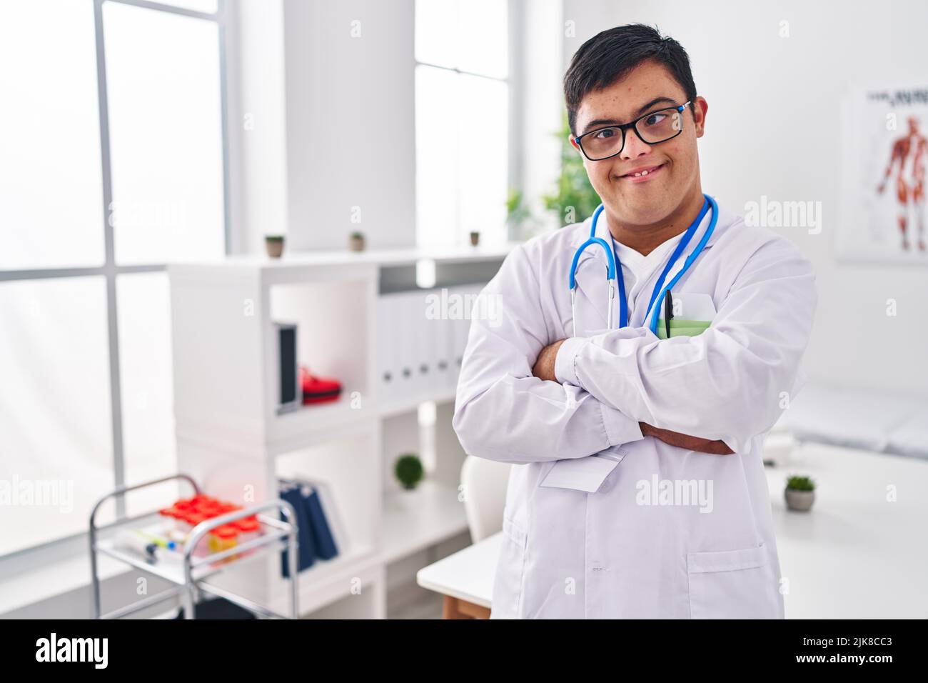 Down syndrome man wearing doctor uniform standing with arms crossed ...
