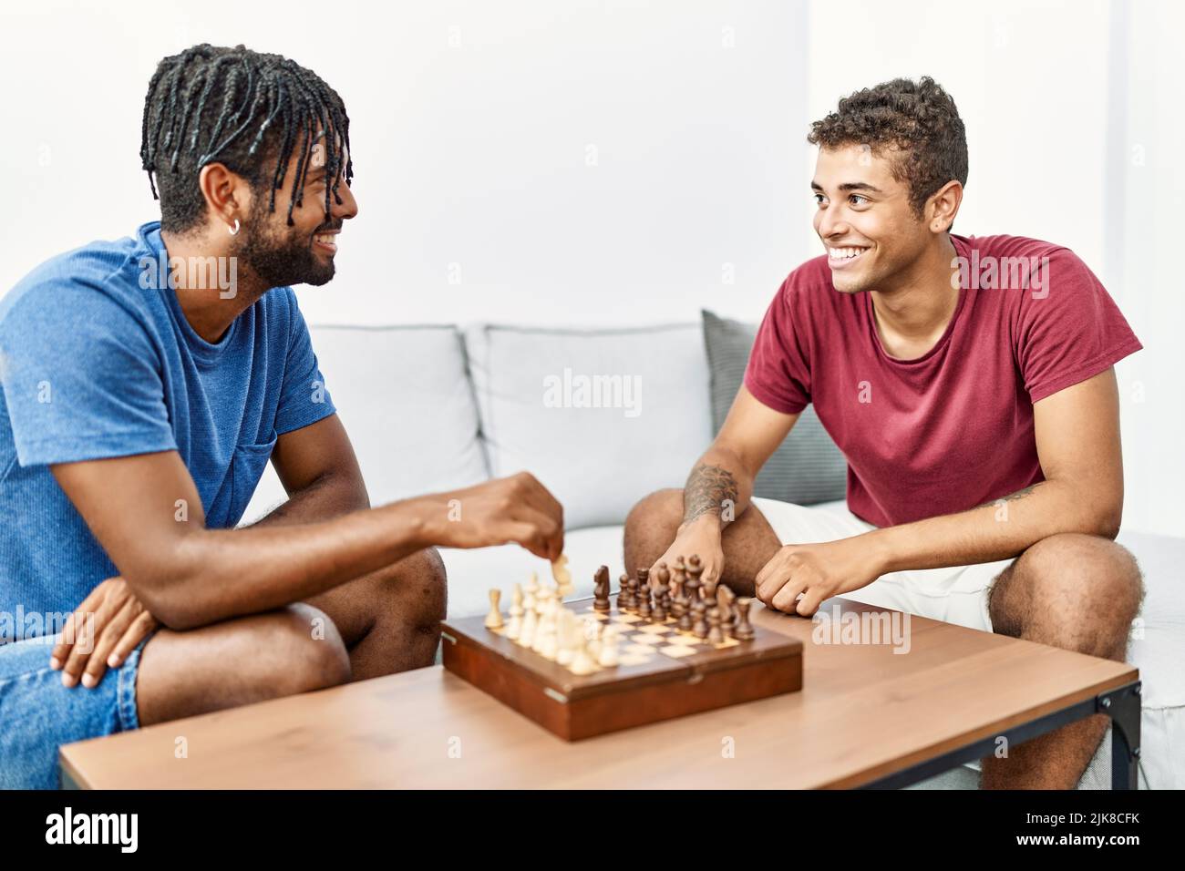 Two men friends playing chess sitting on sofa at home Stock Photo - Alamy
