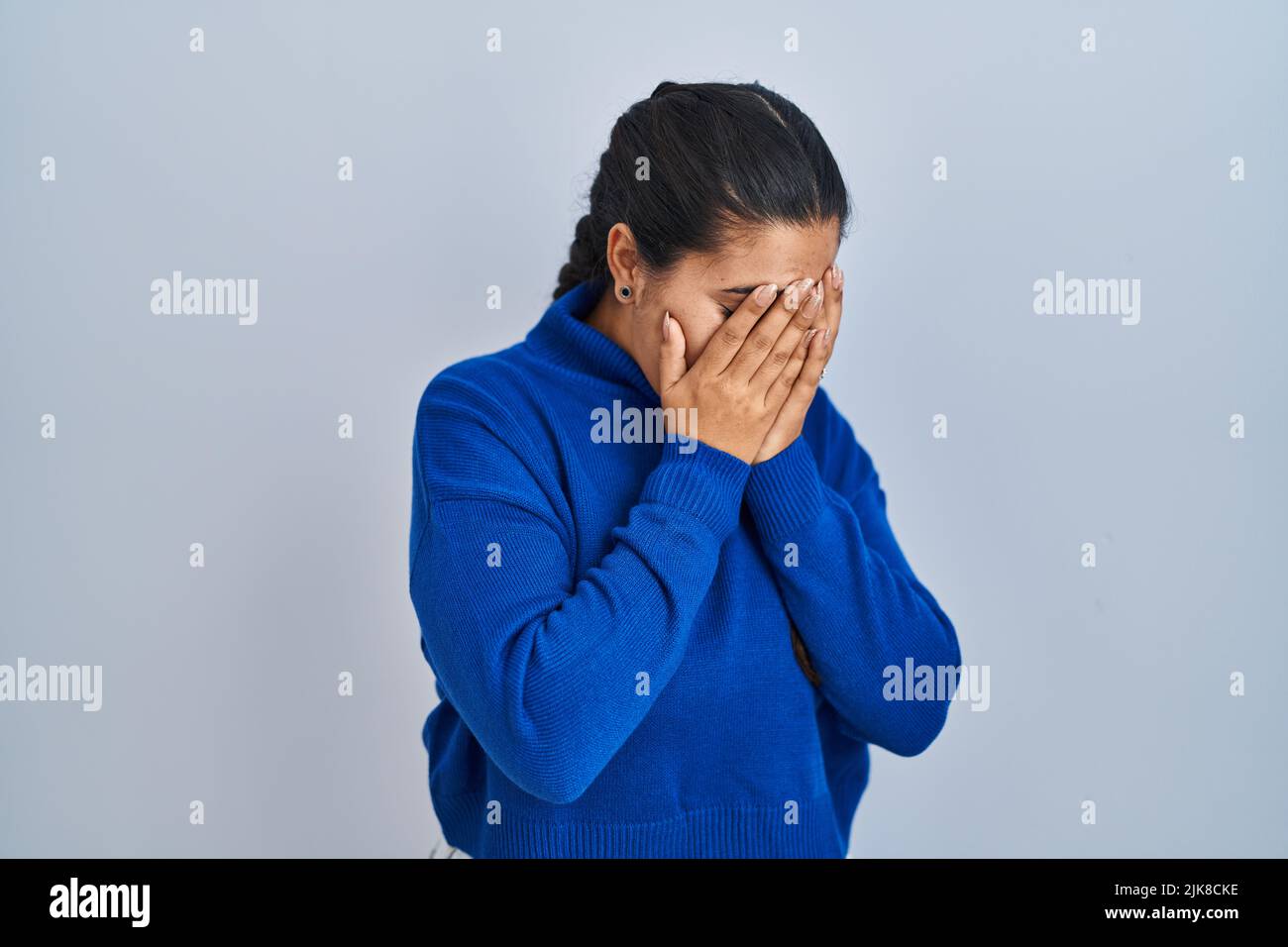 Young hispanic woman standing over isolated background with sad ...