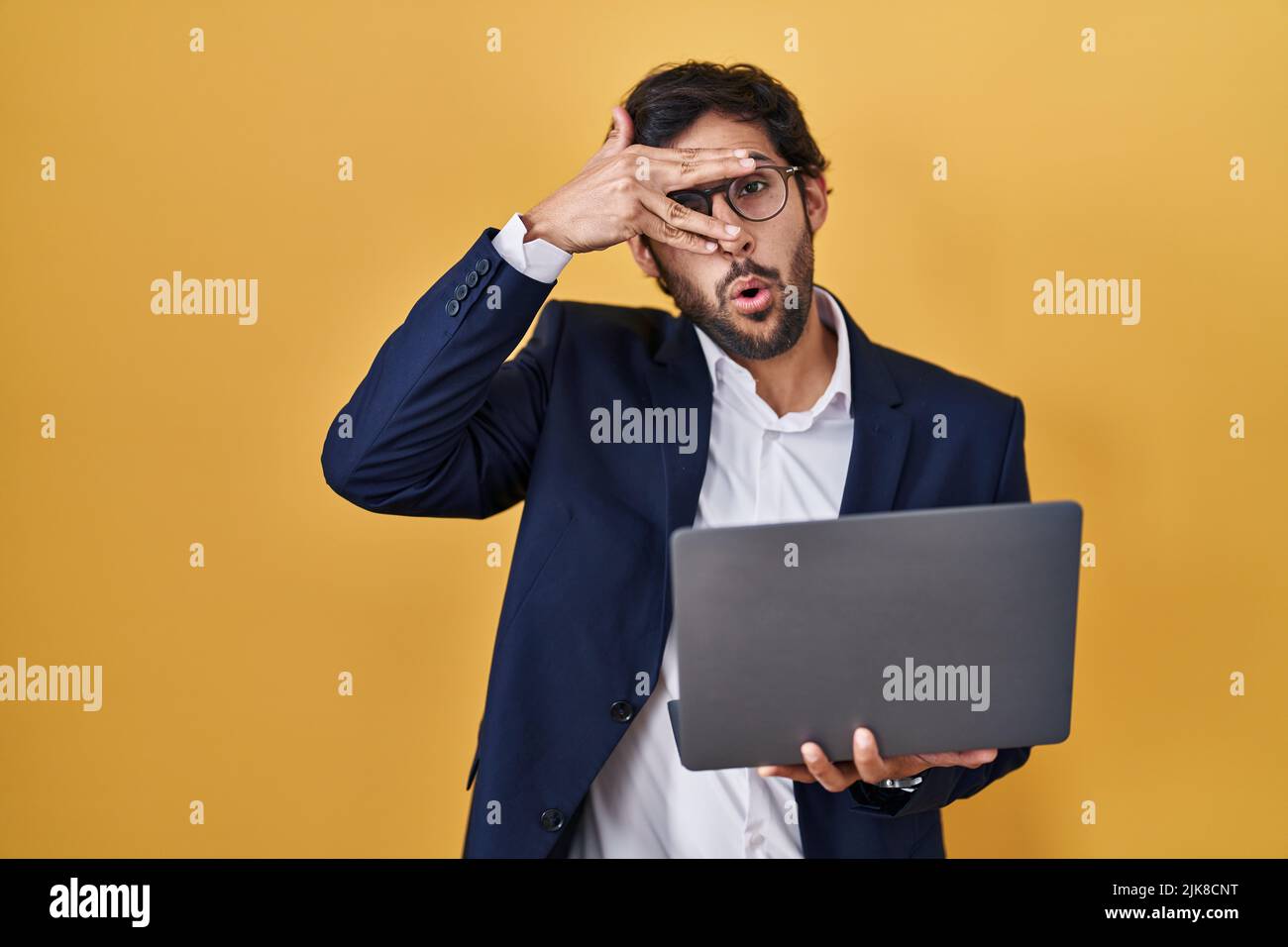 Handsome latin man working using computer laptop peeking in shock ...