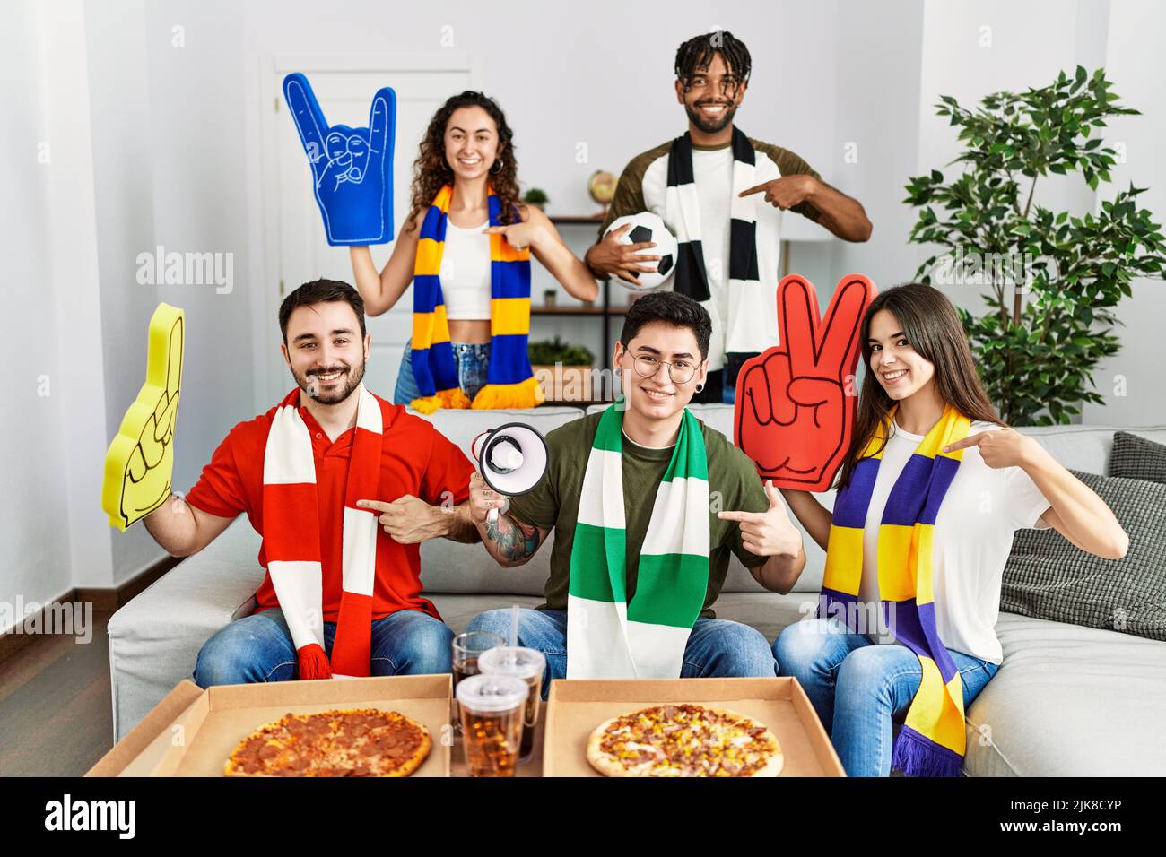 Group of young people wearing team scarf cheering football game ...