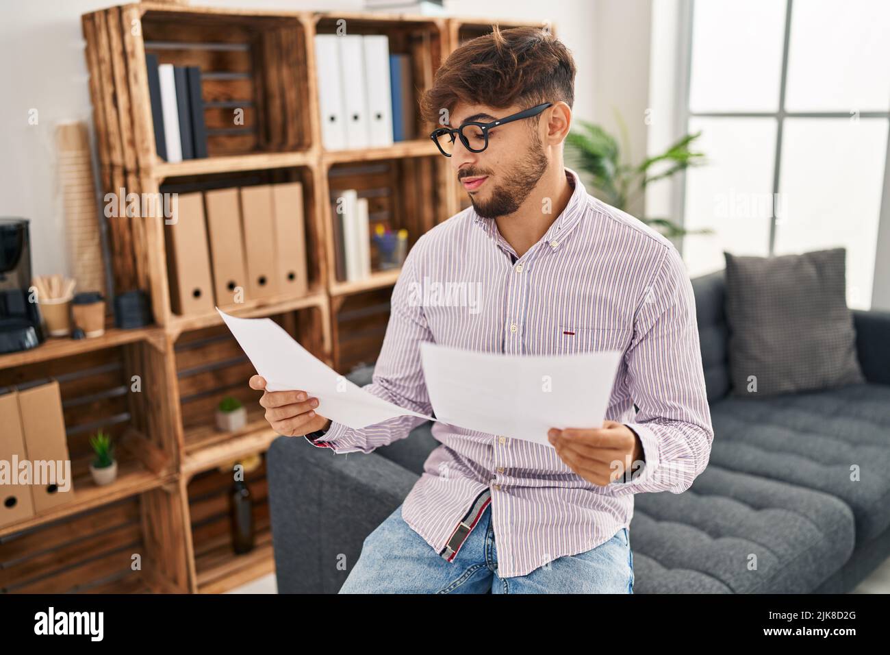Young arab man psychologist reading document at psychology center Stock ...