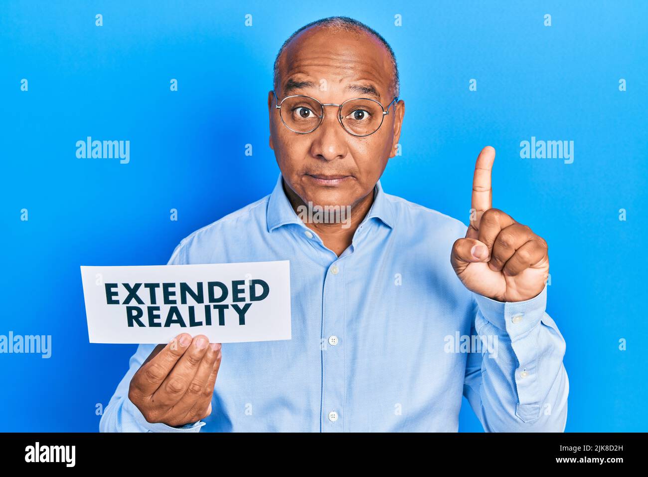 Middle age latin man holding paper with extended reality message ...