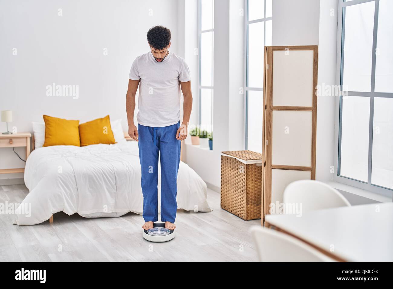 Arab man looking at weight machine to balance weight loss scared and ...