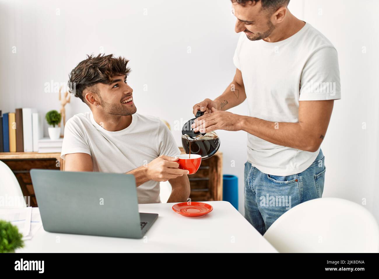 Two hispanic men couple pouring coffee having breakfast at home Stock ...