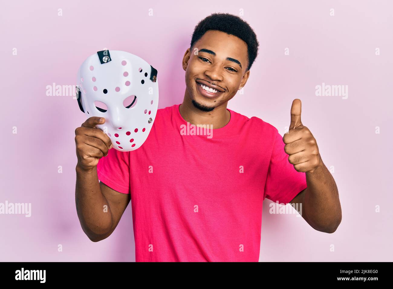 Young african american man holding hockey mask smiling happy and ...