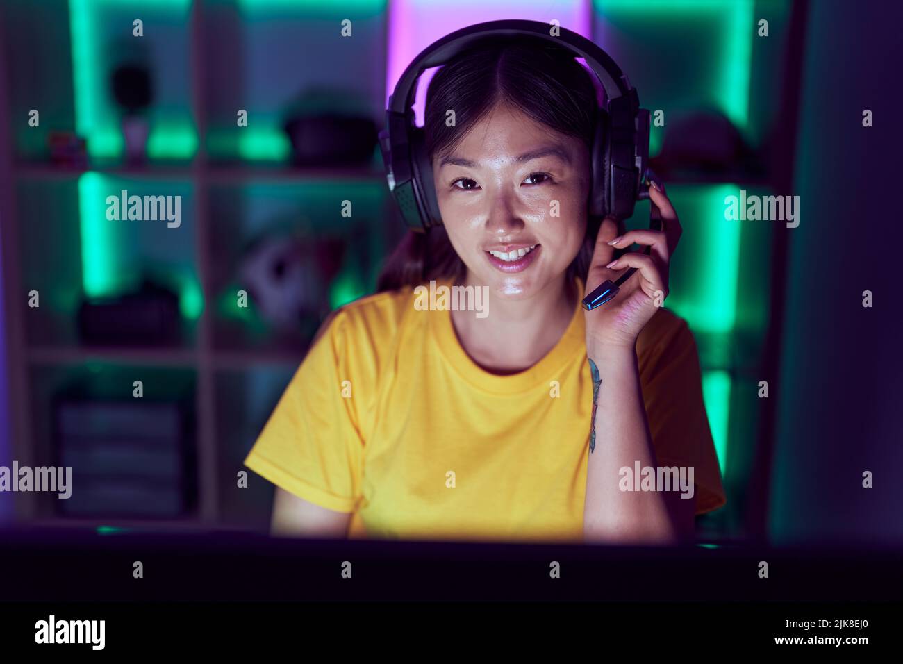 Chinese woman streamer smiling confident using computer at gaming room ...