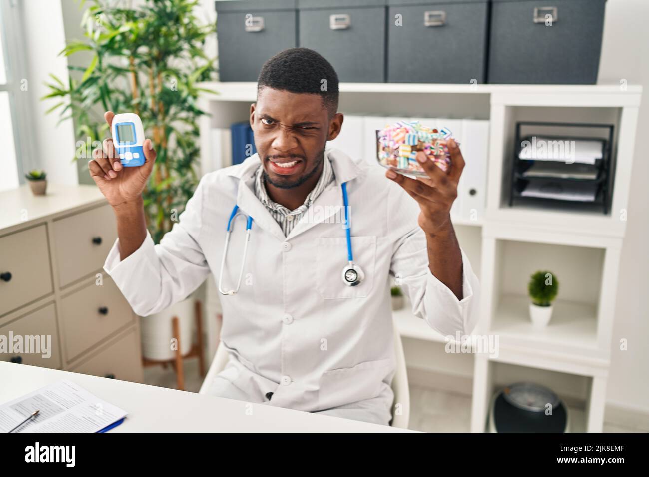 African american doctor man using glucose meter clueless and confused ...