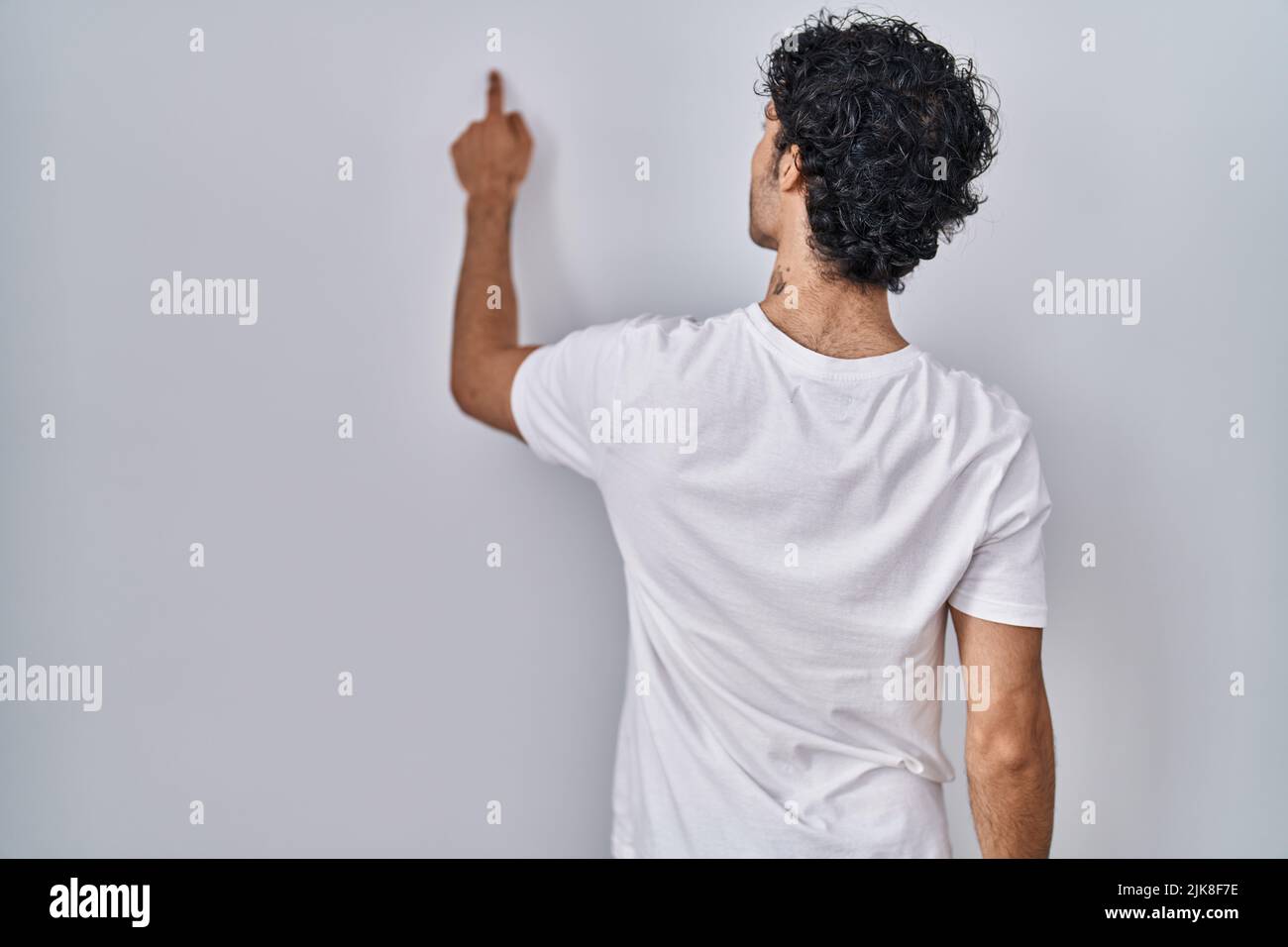 Hispanic man standing over isolated background posing backwards ...