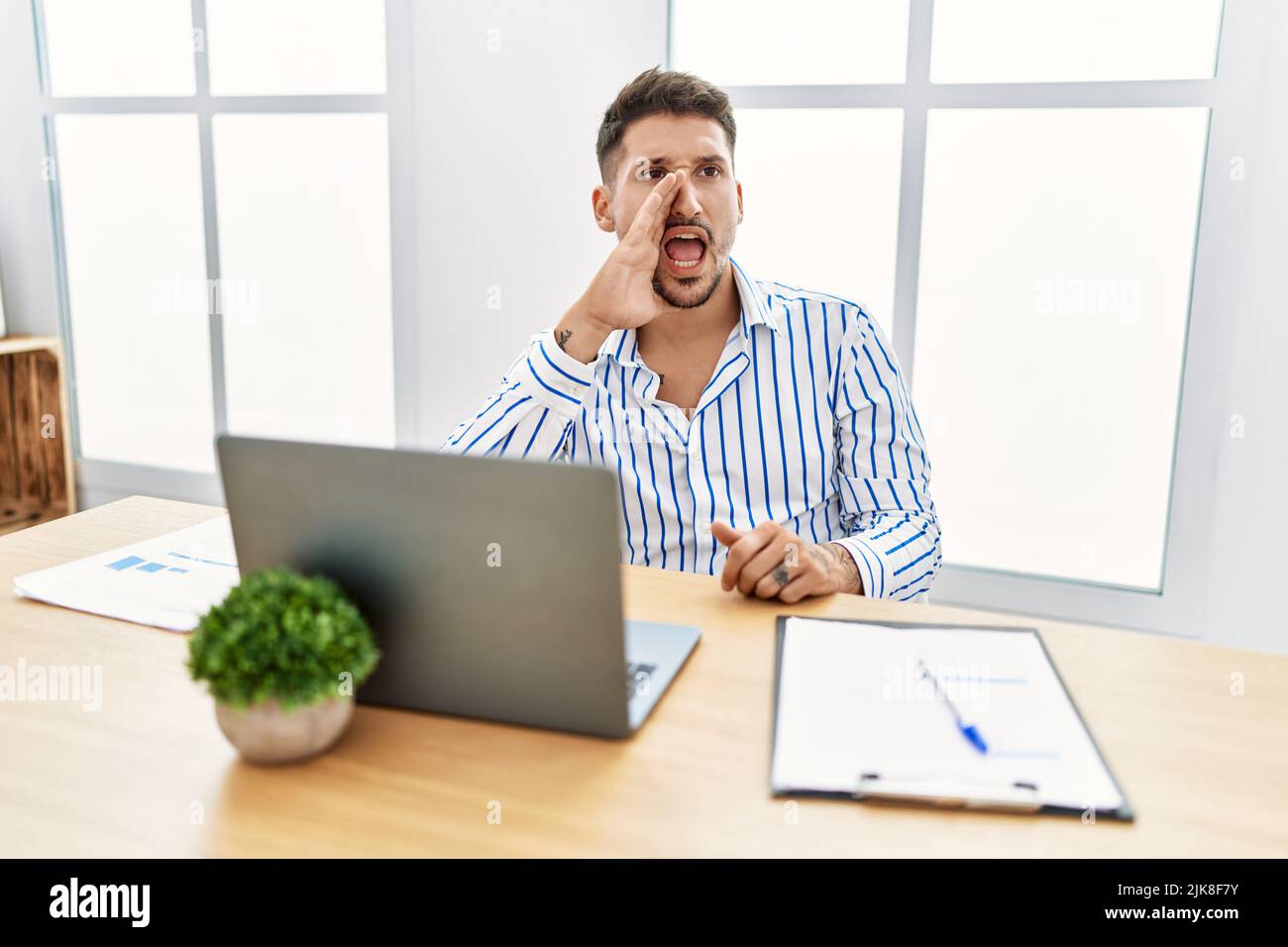 Young handsome man with beard working at the office using computer ...