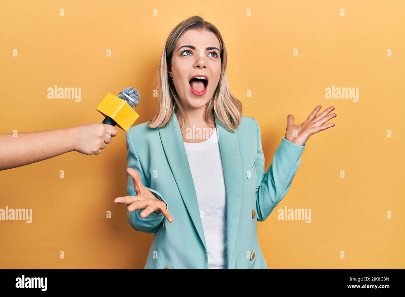 Beautiful caucasian woman being interviewed by reporter holding ...